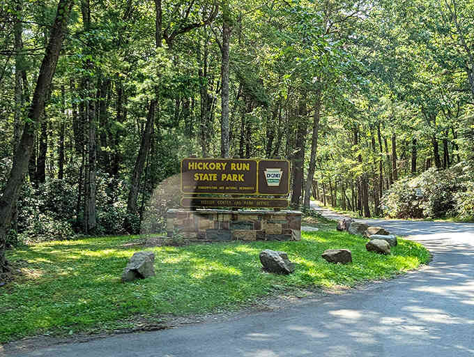 The entrance sign stands ready to welcome you to adventures that have been waiting here all along, patient as stone.