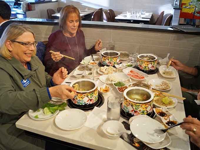 Happy diners enjoying hot pot together &ndash; because the best meals are always the ones shared with good company.