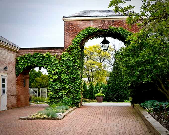 Ivy-covered archways frame pathways leading to garden rooms that reveal new surprises around every manicured corner.