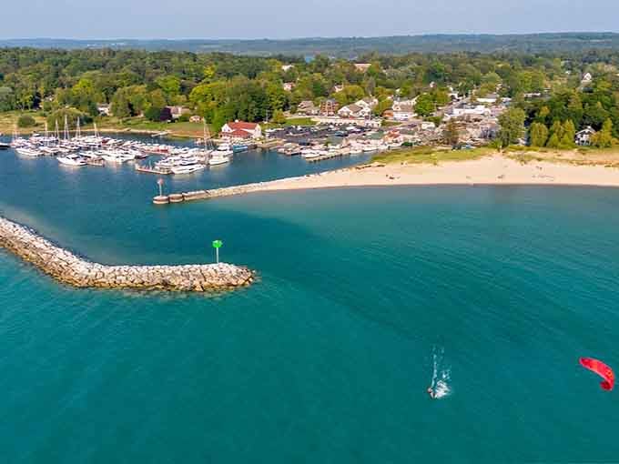Aerial view showing how Leland's harbor, beach, and town create Michigan's answer to coastal perfection.
