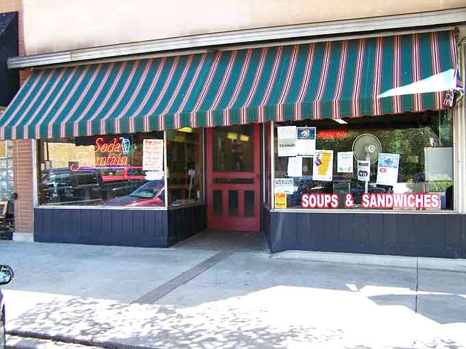 The striped awning beckons like a friendly wave, inviting you to leave the modern world behind for something infinitely sweeter.