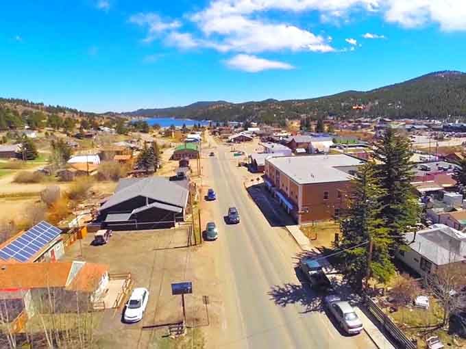 Bird's-eye view reveals a compact mountain community nestled between reservoir and peaks, perfectly sized for authentic living.