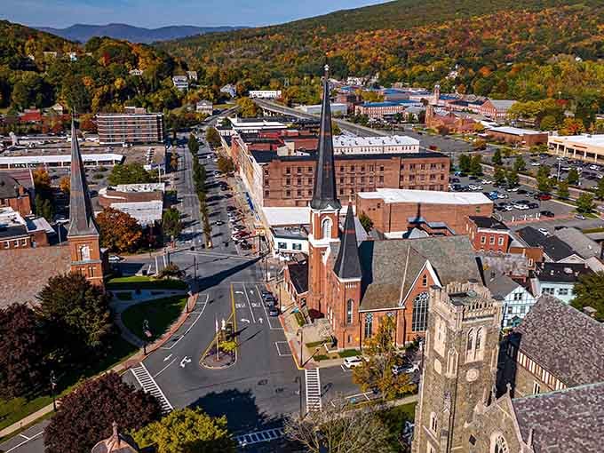 Aerial perspective reveals North Adams nestled in autumn glory, mountains cradling this affordable gem like nature's own treasure chest.