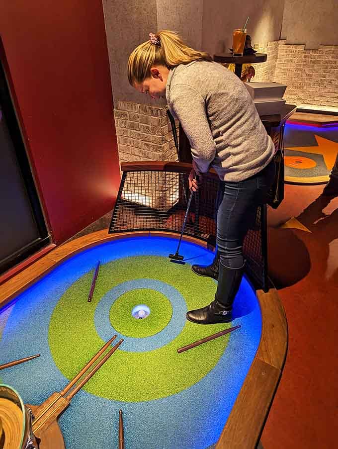Concentration meets neon glow as another player attempts to prove their putting prowess under pressure.