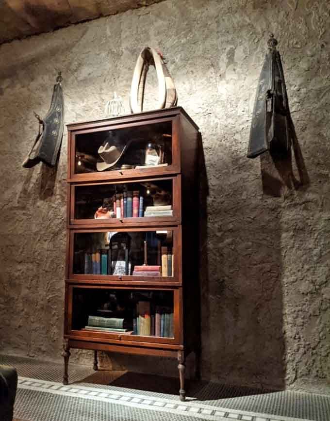 A vintage bookcase topped with a lasso, because even literature needs a Western touch down here.