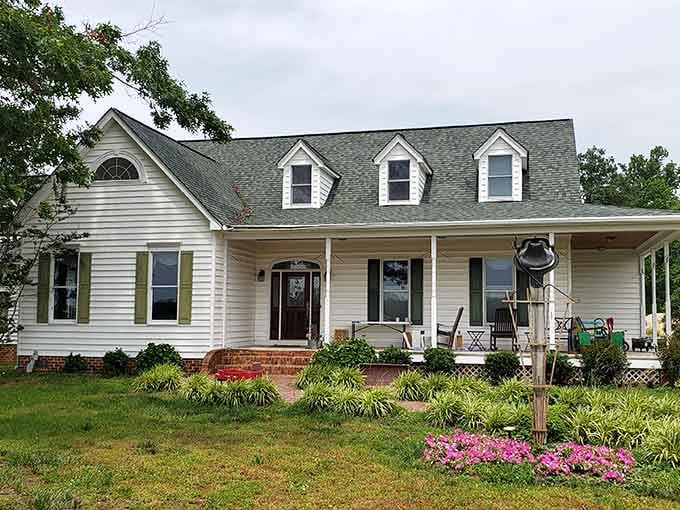 The farmhouse stands proud with its welcoming porch, anchoring generations of agricultural tradition in Southern Maryland's fertile soil.