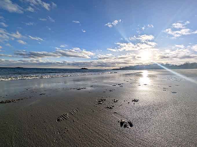 Morning light dances across wet sand, creating mirror reflections that double the beauty of this coastal gem.