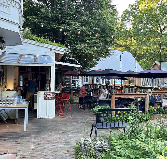 String lights and umbrellas transform this outdoor dining space into an evening gathering spot where conversations flow as smoothly as wine.