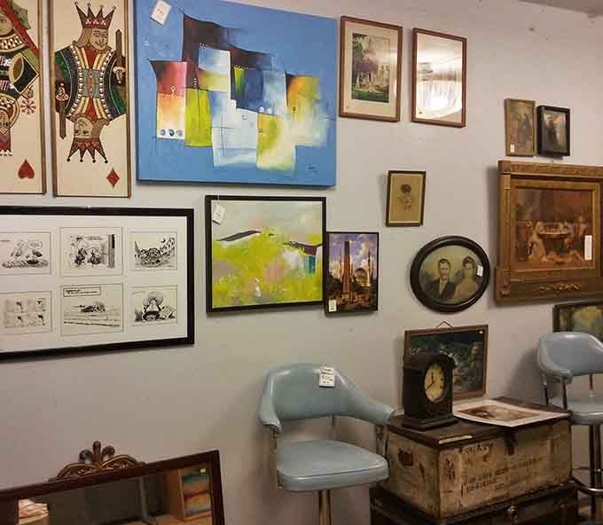 Framed artwork creates an eclectic gallery wall waiting to happen, mixing abstract pieces with vintage portraits and playful prints.