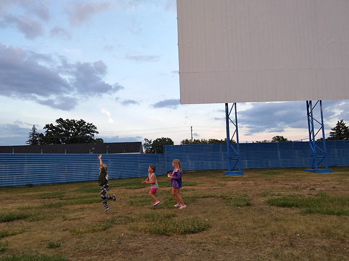 Little ones running free on the grass before showtime, living their best pre-movie life in comfortable pajamas.