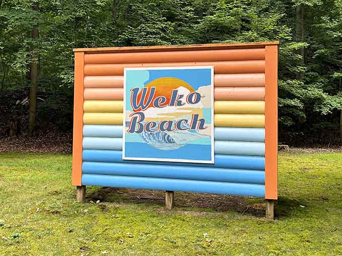 The cheerful welcome sign promises exactly what it delivers: a beach worth finding and remembering.