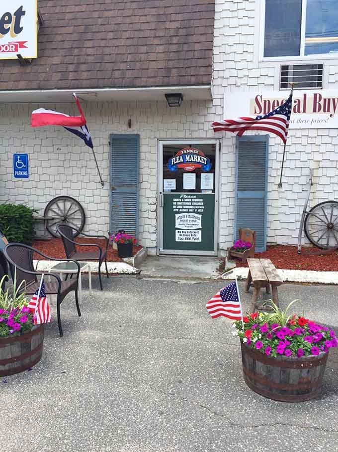 The welcoming entrance with barrel planters and flags promises treasures await inside this unassuming Palmer building's doors.