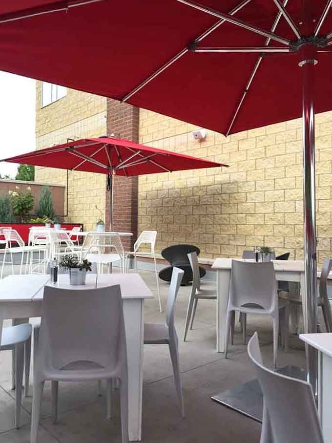 Red umbrellas provide shade while you enjoy fresh salads and sandwiches in the open air bliss.