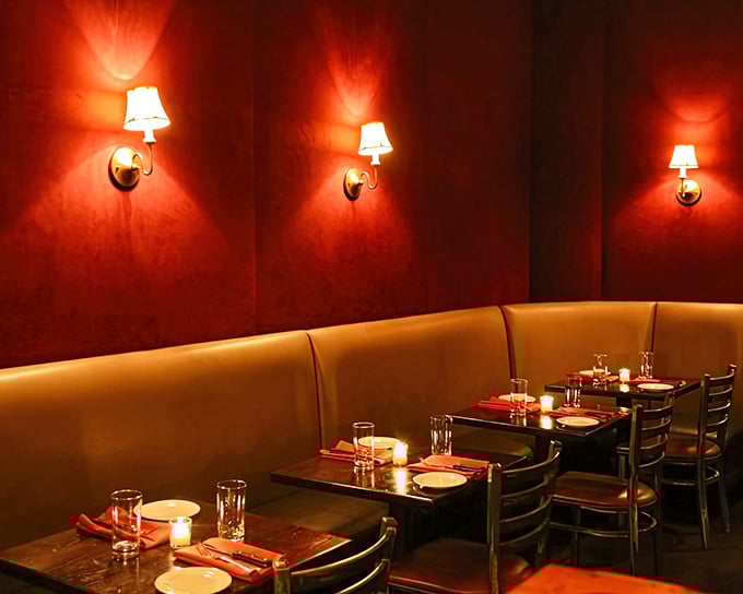 That warm amber glow against deep red walls creates the kind of intimate atmosphere where great conversations happen over even greater steaks.