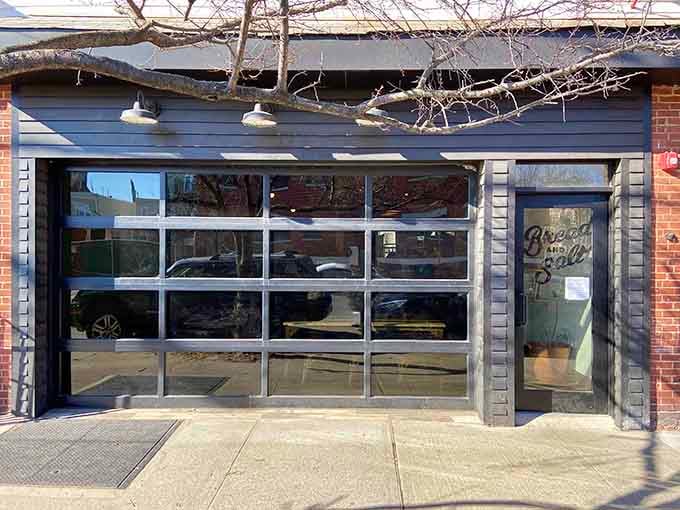 Modern garage-style doors open wide to reveal Jersey City's wood-fired pizza paradise where simplicity meets sophistication.