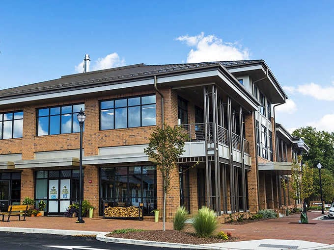 Modern downtown architecture meets small-town charm where glass windows reflect big-city dining dreams in unexpected places.