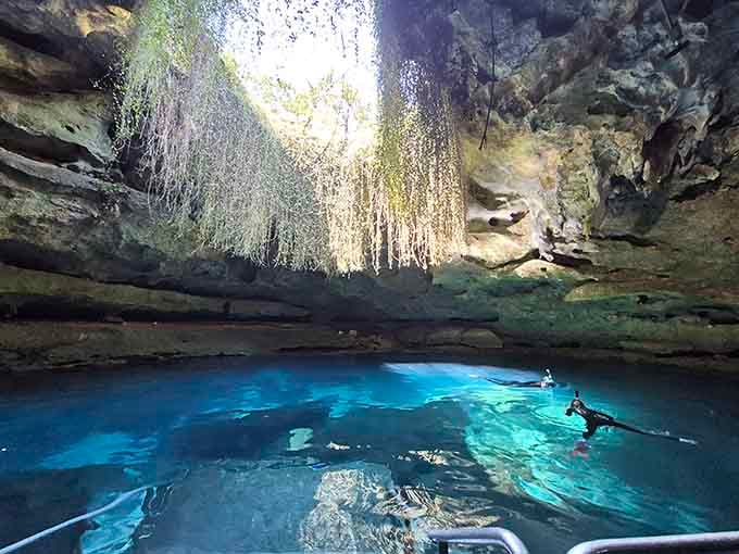 Sunlight streams through ancient limestone like nature's own cathedral, illuminating water so blue it seems impossible.