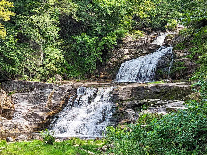 Nature's own staircase cascades down rocky ledges, creating a symphony of rushing water and green tranquility.