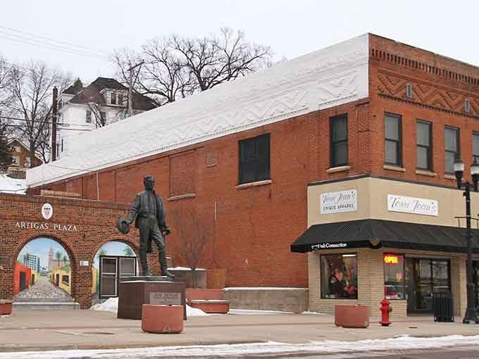 Historic brick buildings and a bronze statue welcome you to downtown Montevideo's charming plaza on a winter day.