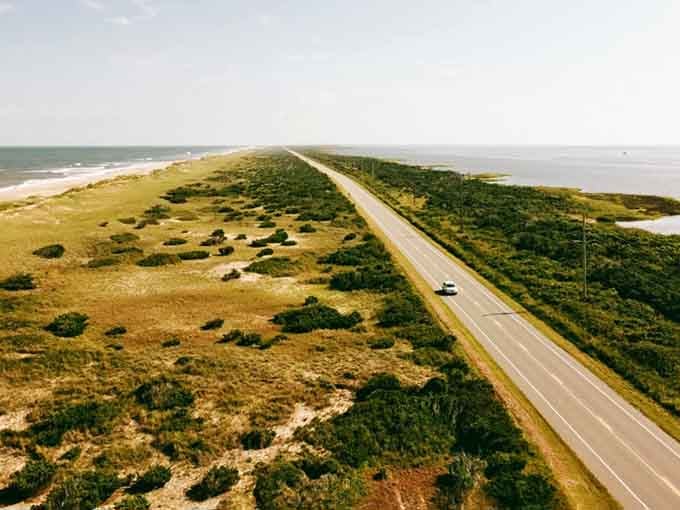 From above, the coastal highway looks like someone drew a line between two different worlds with a ruler.