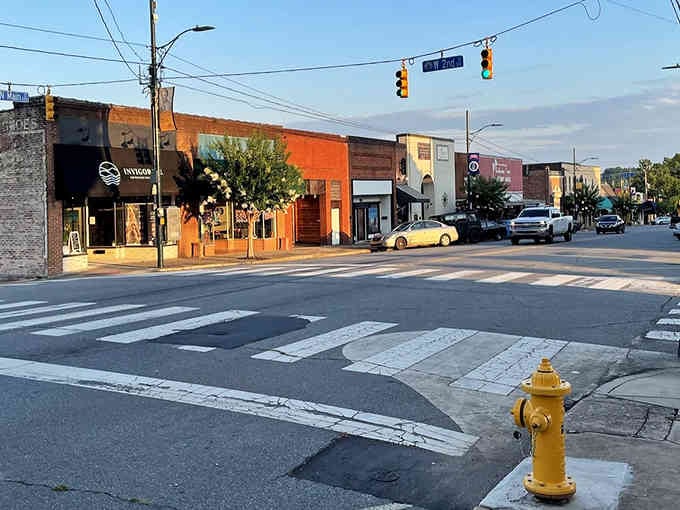 Golden hour light bathes these colorful storefronts where the only traffic jam involves friendly neighbors catching up mid-crosswalk.