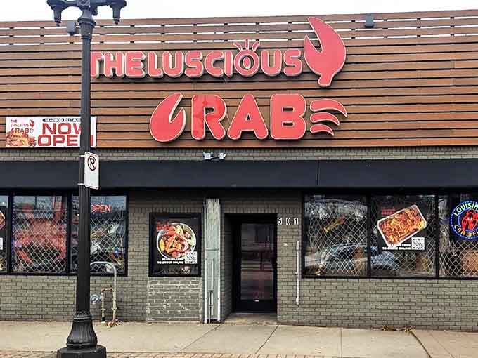 That bold coral signage against wood paneling promises Cajun seafood adventures hiding behind those checkered windows below.