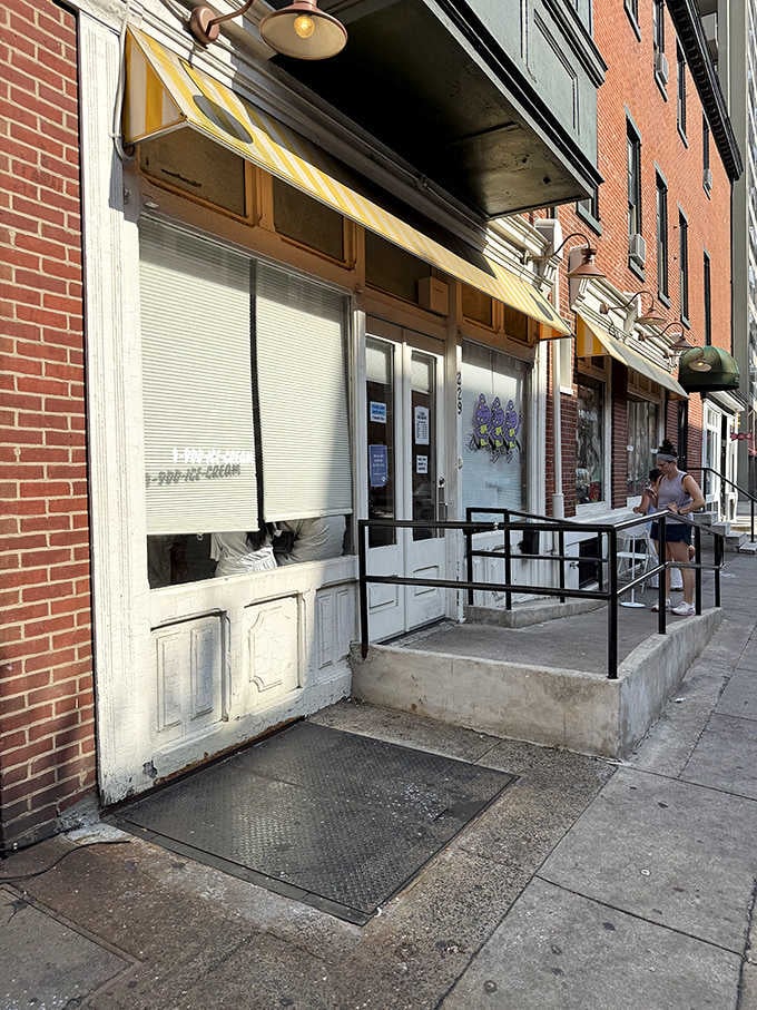 That yellow-striped awning beckons like a lighthouse for ice cream lovers navigating the Philadelphia streets below.