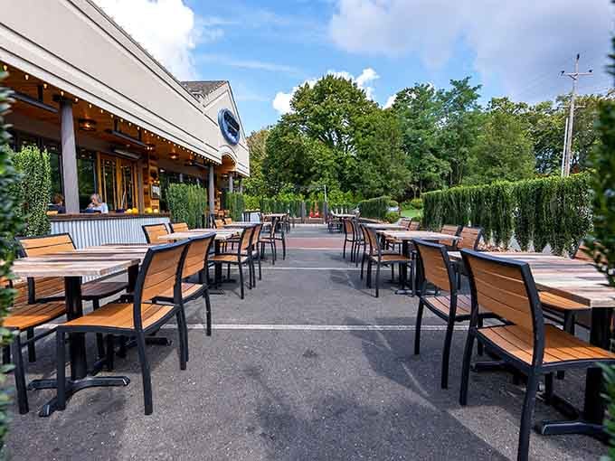 The spacious outdoor patio surrounded by greenery creates a peaceful escape where fresh seafood tastes even better.