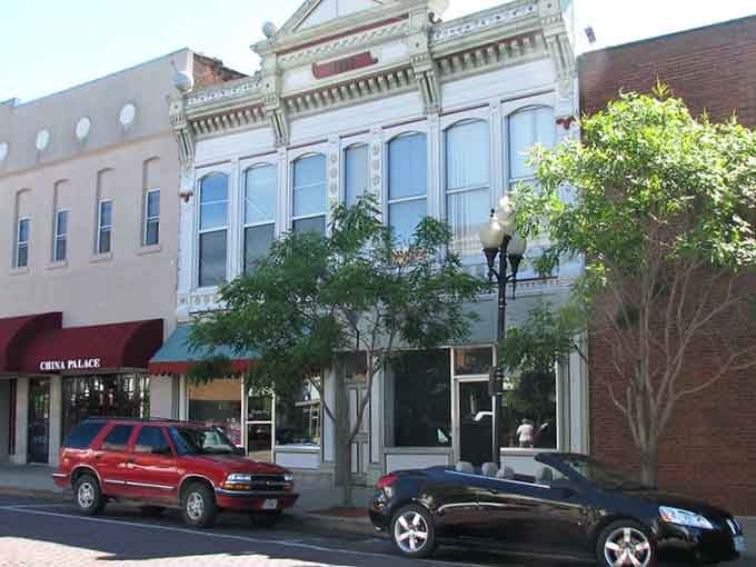 That ornate white facade practically demands you slow down and appreciate craftsmanship from a more elegant era.