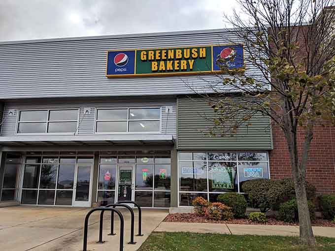 The green awning and brick facade create a welcoming storefront where fresh donuts have been the main attraction for generations.