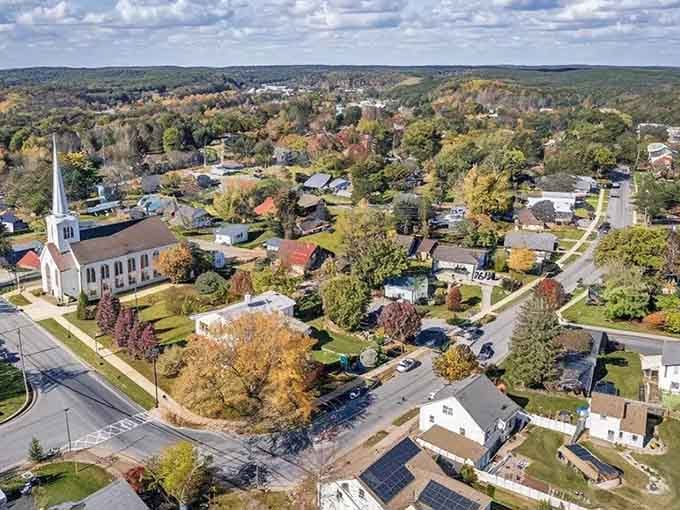 This bird's-eye view reveals a patchwork of fall colors surrounding the peaceful town green below.