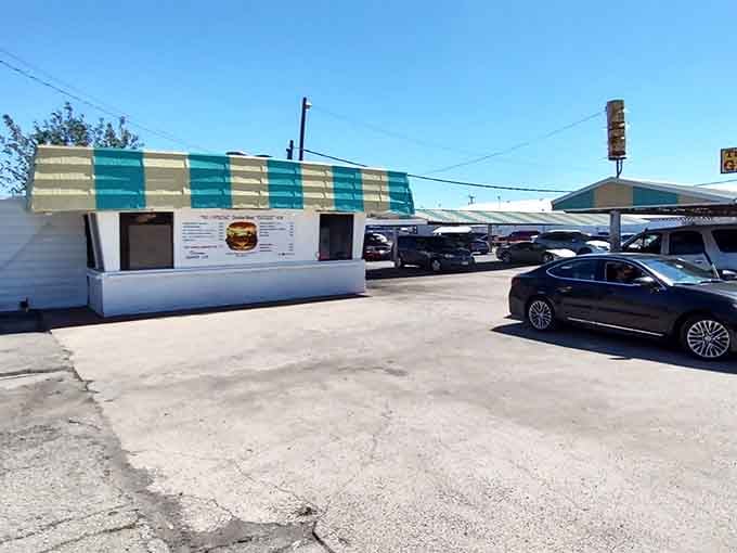 The vintage drive-in stands ready under blue skies, where carhops still deliver happiness on a tray.