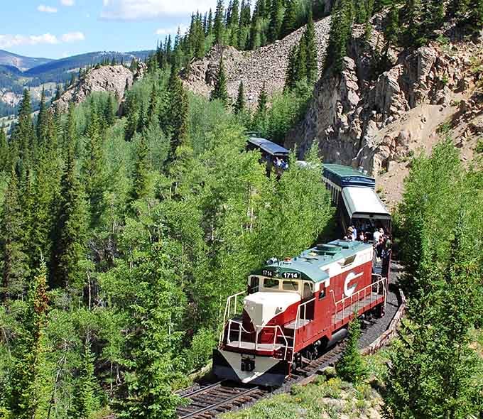 Winding through pine-covered slopes, this red and white engine proves the journey really is better than the destination.
