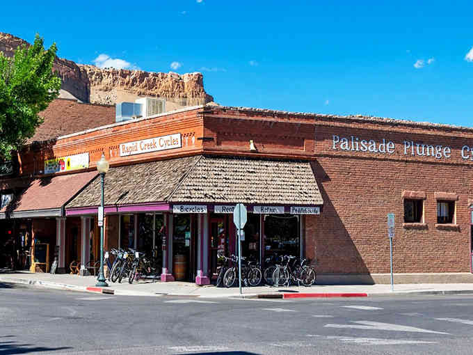 Brick storefronts and bike racks line this charming street where peach orchards meet small-town hospitality and mountain views.