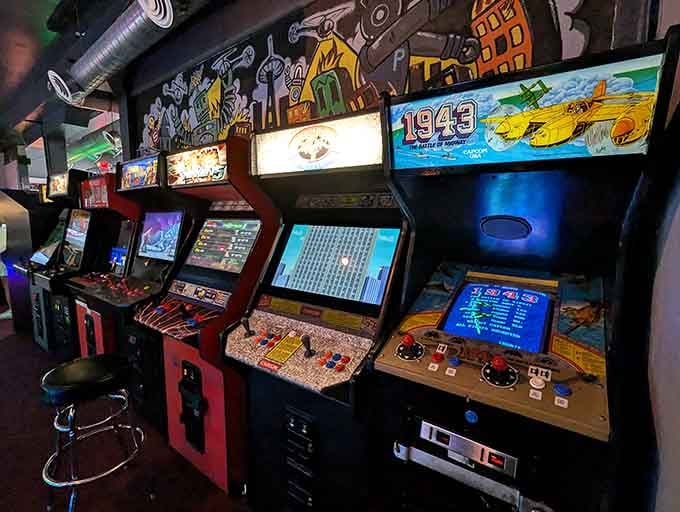 Rows of vintage arcade cabinets stand ready like old friends, each one holding memories you didn't know you missed.