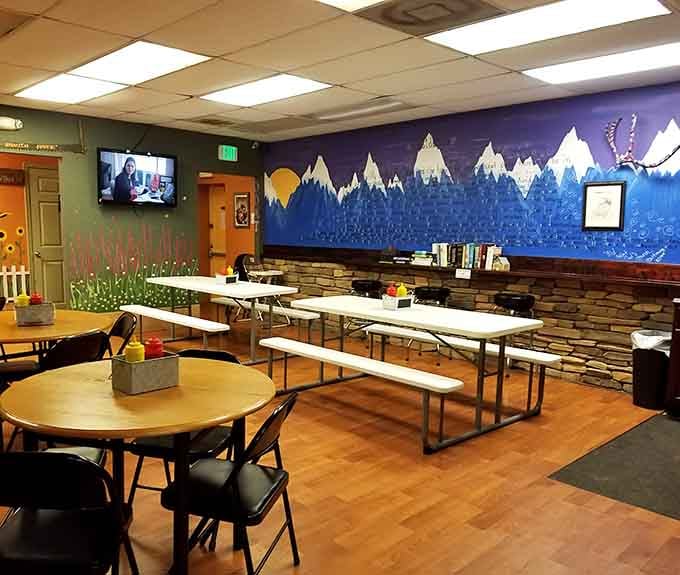 Mountain murals and picnic tables create a casual vibe where strangers become friends over sandwiches.