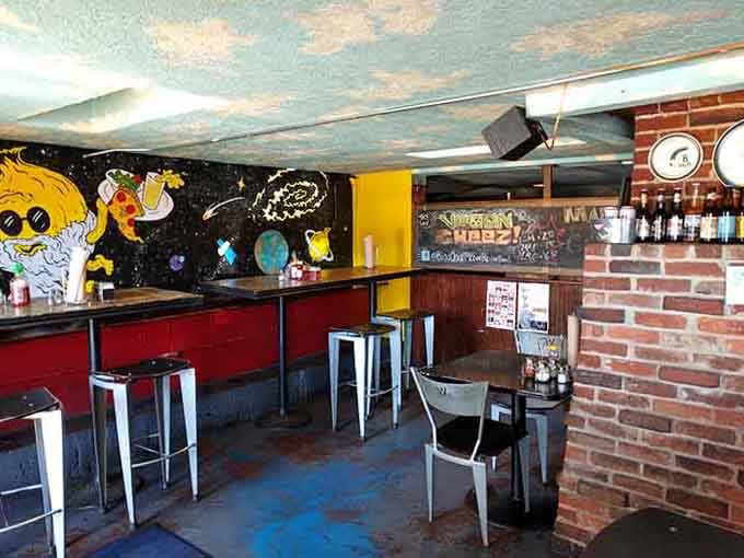 Space-themed murals meet exposed brick, because why choose between cosmic and cozy when you can have both?