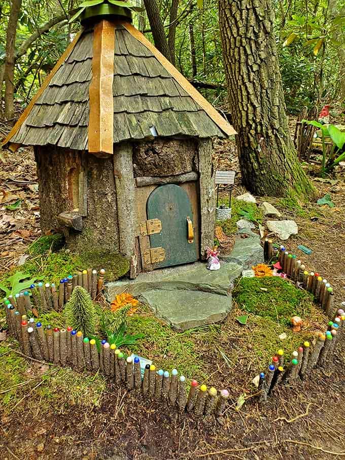 This fairy house has better curb appeal than most human condos, complete with a picket fence made of twigs.