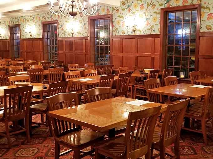 Classic nautical charm meets comfortable dining where wood paneling and floral wallpaper create an unexpectedly cozy atmosphere.