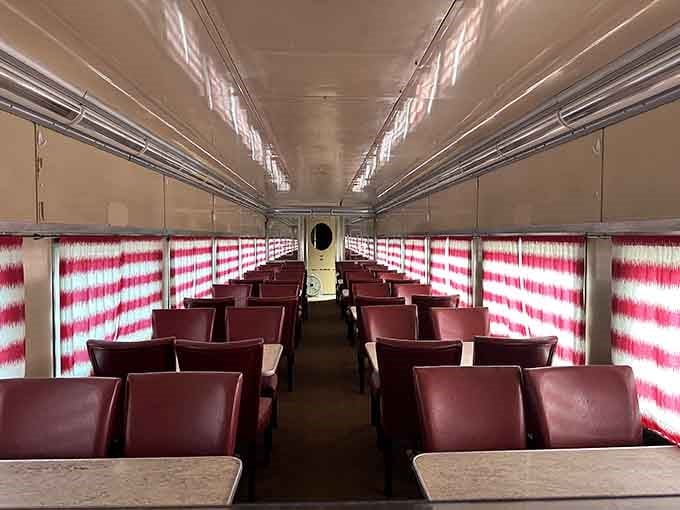 Step inside where burgundy seats and striped curtains transport you straight to railroad's golden age.