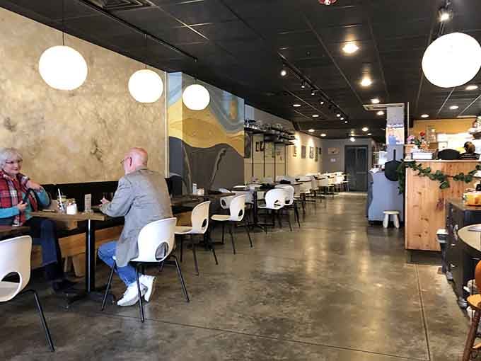 Modern meets cozy in a space where concrete floors and globe lights create the perfect lunch atmosphere.