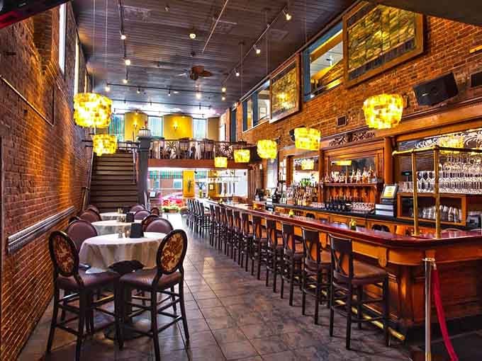 Exposed brick, warm lighting, and that gorgeous wooden bar create an atmosphere that's both sophisticated and welcoming.