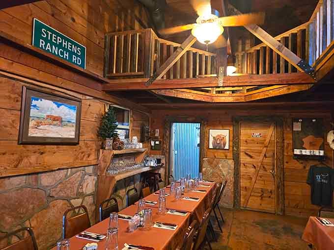 Wood paneling, a stone fireplace, and a loft overhead create the kind of warmth that makes strangers feel like neighbors.