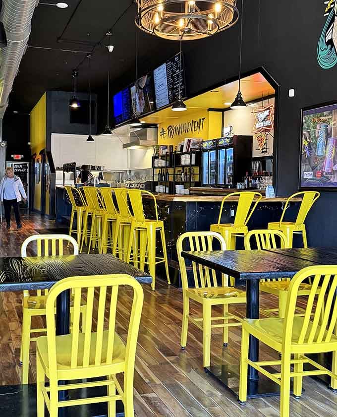 Those cheerful yellow chairs against black walls create the kind of modern vibe that makes dining feel like an event.