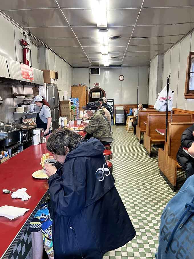 Red vinyl stools and checkered floors create a time capsule where strangers become friends over plates of miniature perfection.