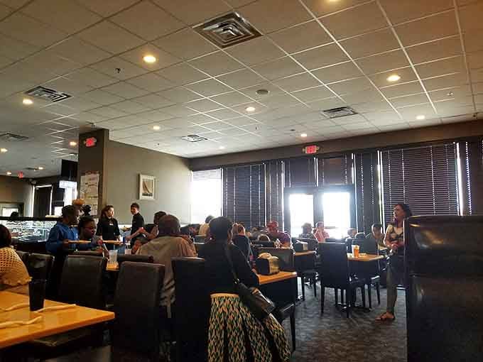 Natural light streams through those windows like a spotlight on happiness, illuminating tables full of people living their best buffet lives.