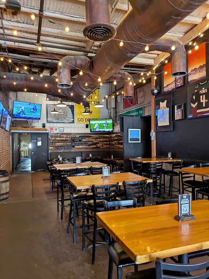 Industrial chic meets neighborhood brewery, where exposed ductwork and string lights create the perfect atmosphere for ghost hunting.