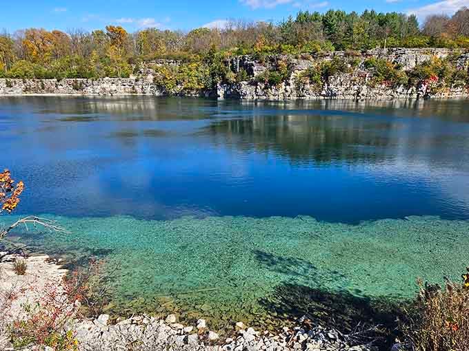Crystal-clear quarry water meets autumn colors in a scene that belongs on a postcard, not hidden in Logansport.