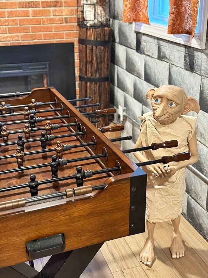 Dobby guards the foosball table like it's the Chamber of Secrets, ready to challenge any wizard brave enough.