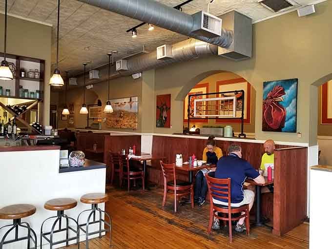 Exposed ductwork meets warm wood and vibrant art in a space that feels both contemporary and welcoming to everyone.